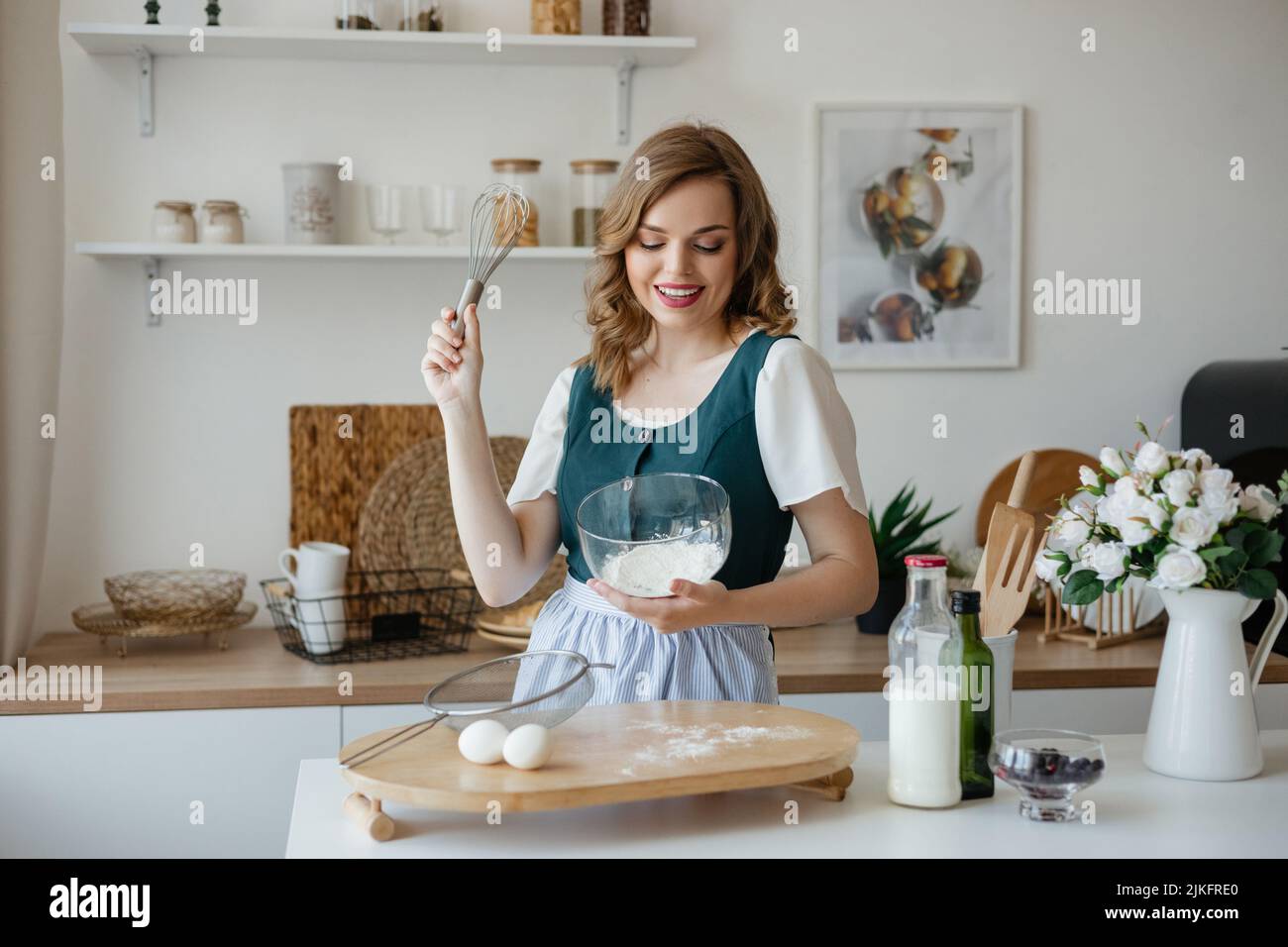 Beautiful girl housewife cooks in the kitchen Stock Photo - Alamy