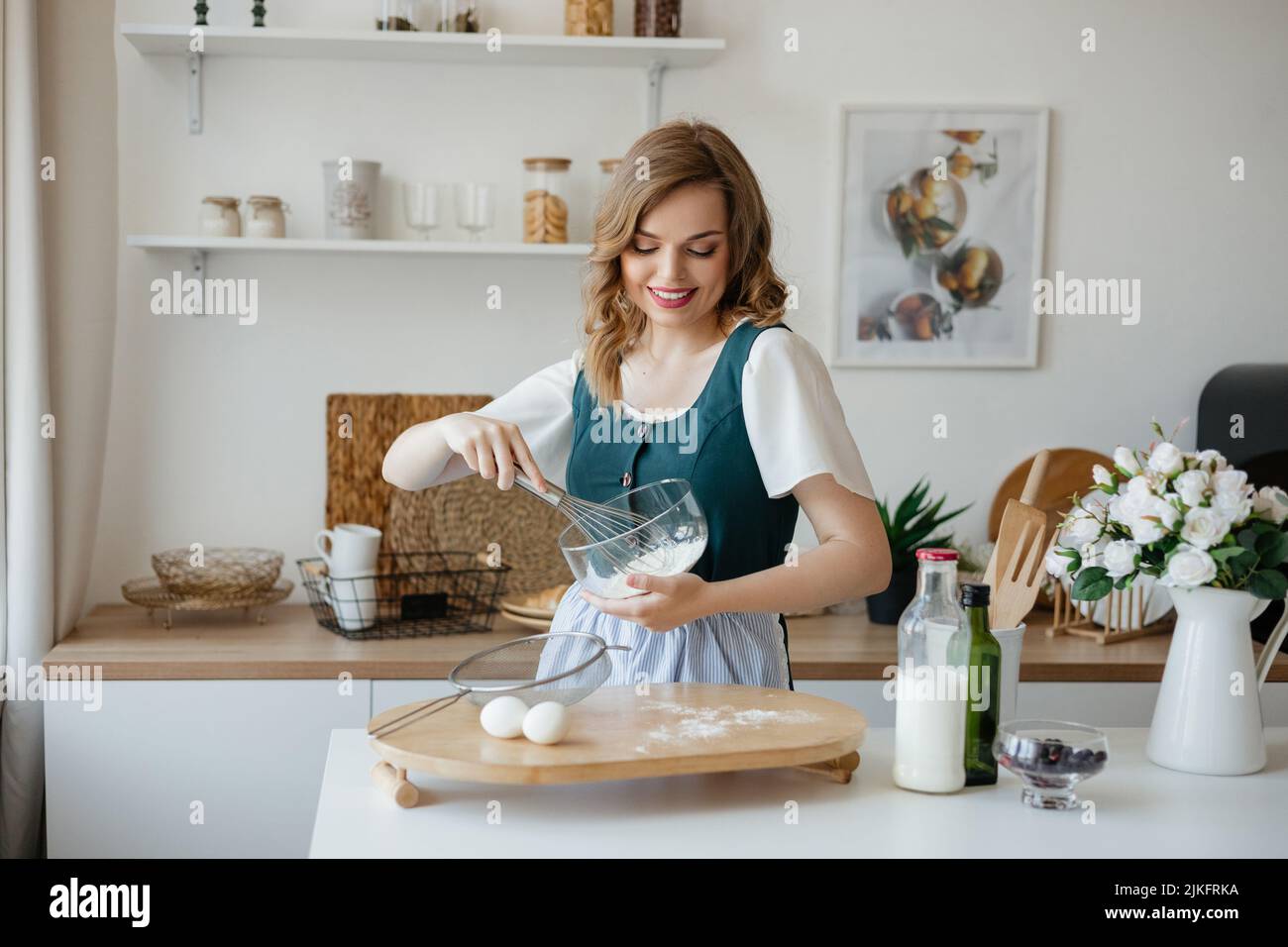 Beautiful girl housewife cooks in the kitchen Stock Photo - Alamy