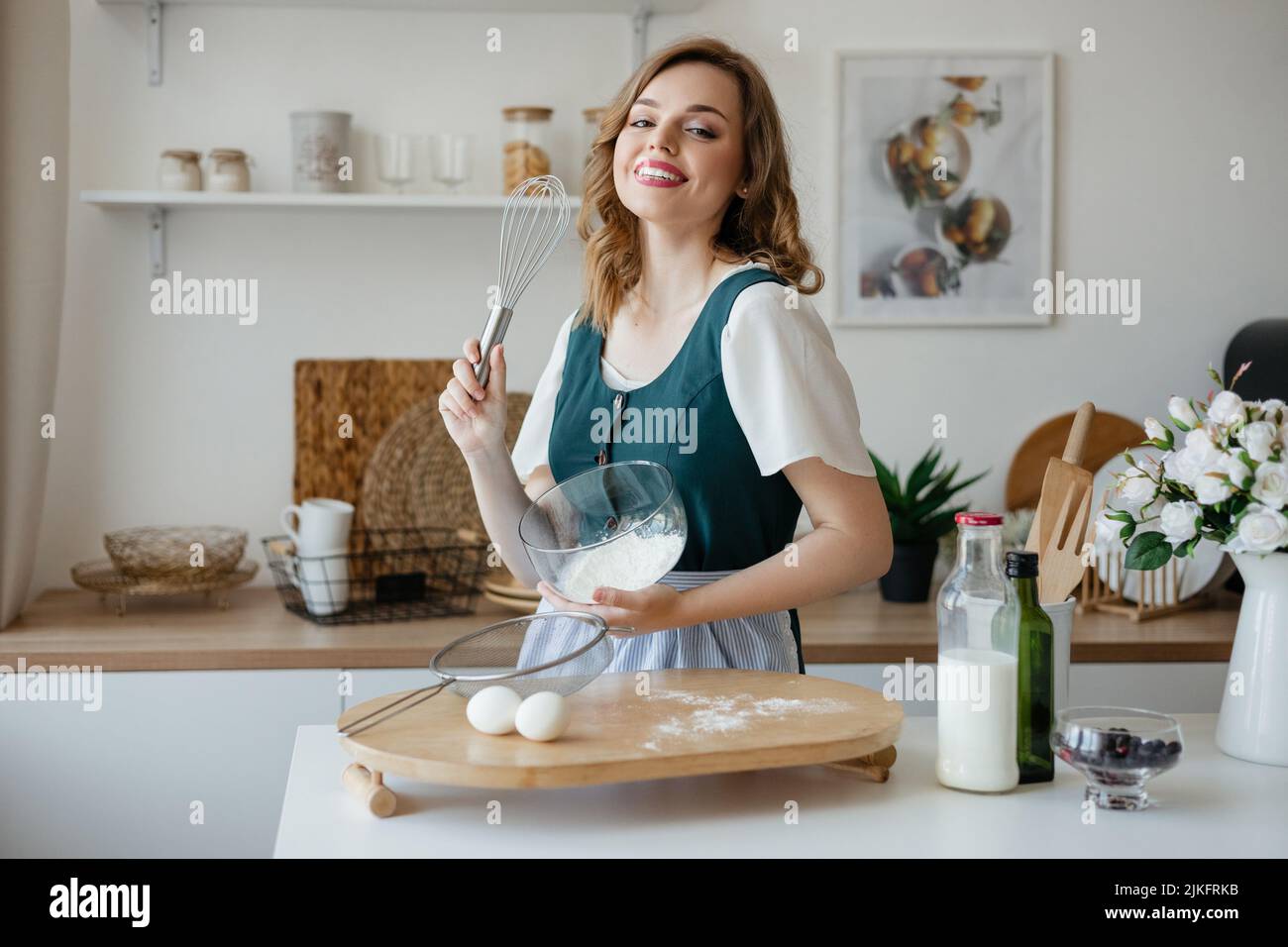 Beautiful girl housewife cooks in the kitchen Stock Photo - Alamy