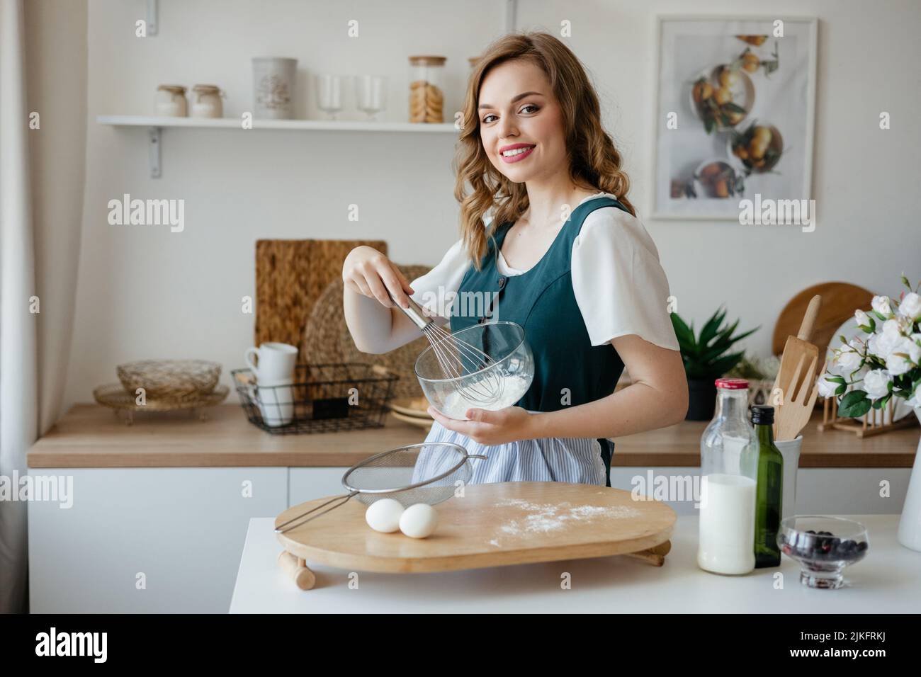 Beautiful girl housewife cooks in the kitchen Stock Photo - Alamy