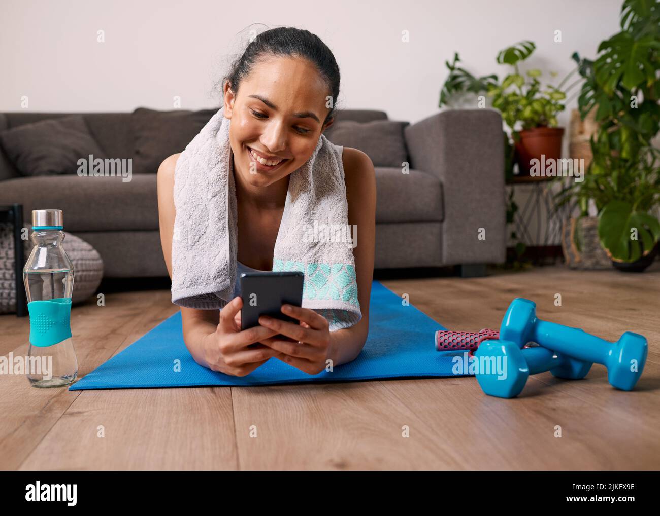 A young multi-ethnic woman tracks her exercise on fitness app after ...