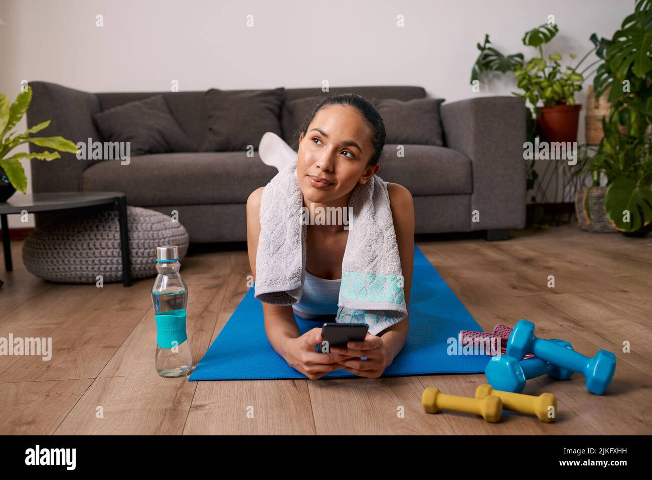 A young multi-ethnic woman tracks her exercise on fitness app after ...