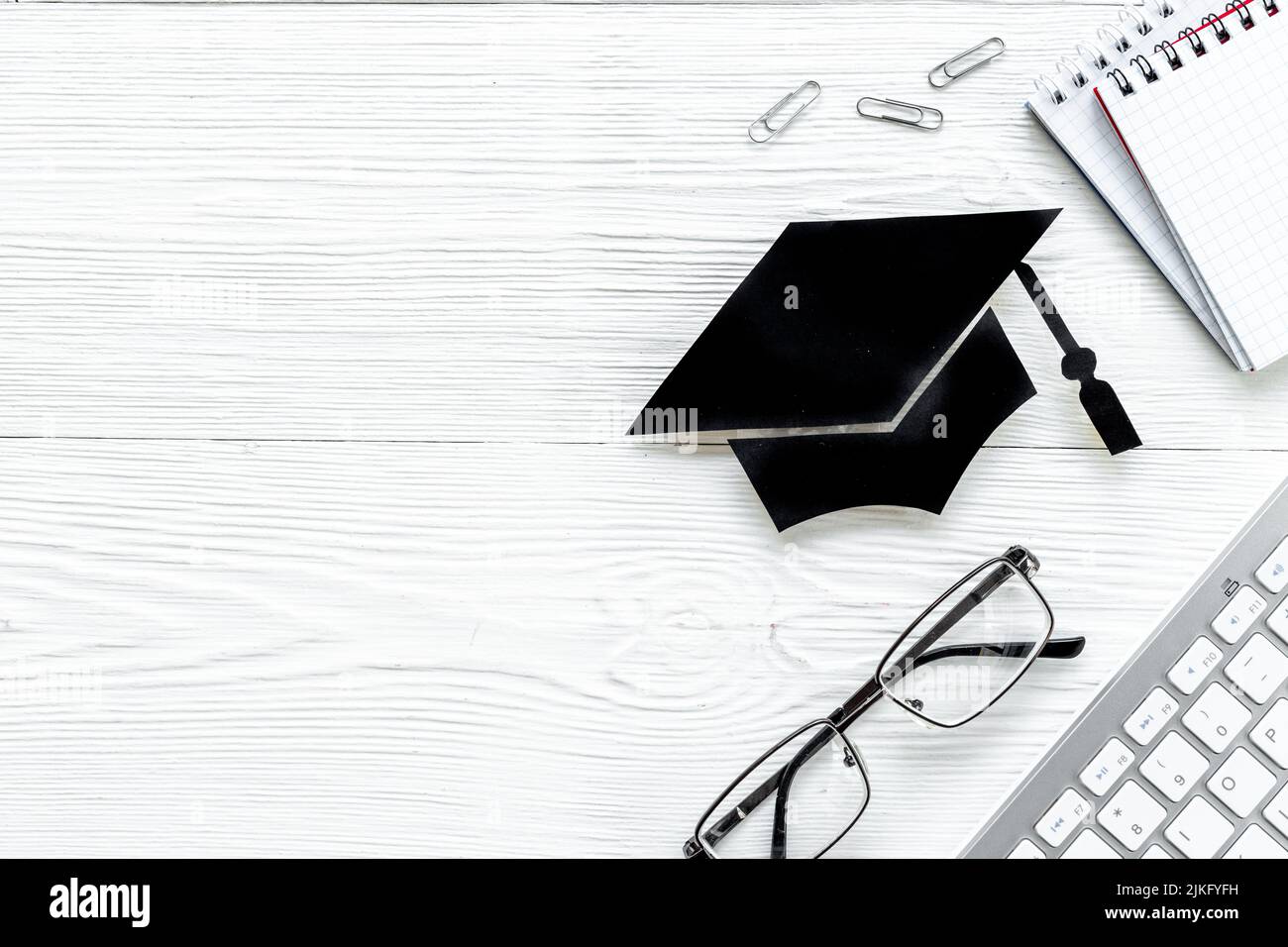 Graduation hat on students table. Masters or Bachelors degree concept ...
