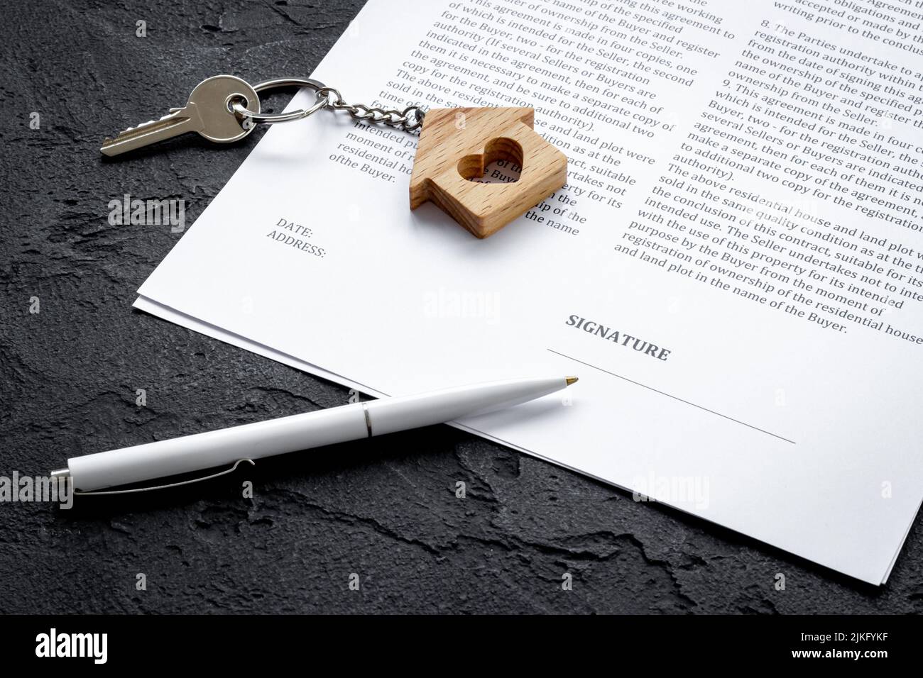 House shaped keychain with house purchase agreement Stock Photo - Alamy