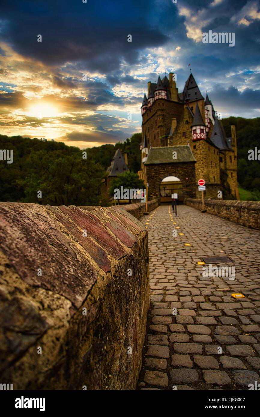 A vertical shot of the empty pathway of Eltz Castle at sunset ...