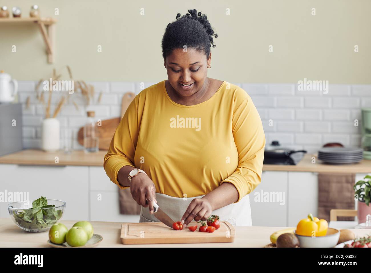 Waist up portrait of smiling black woman cooking healthy meal in ...