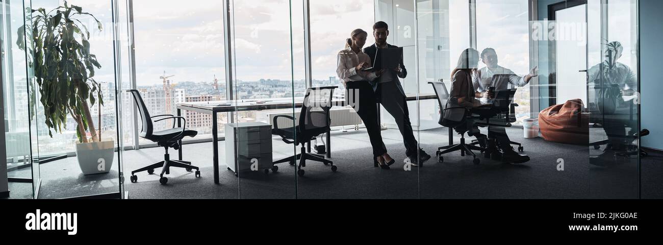 People standing near table, team of young businessmen working and ...