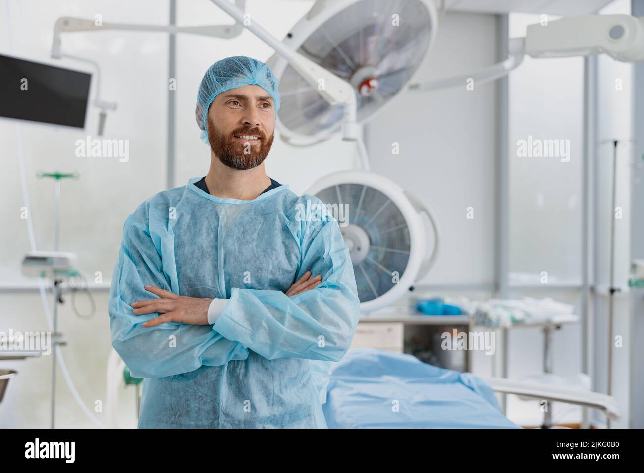 Professional surgeon standing in operating room with crossing hands ...