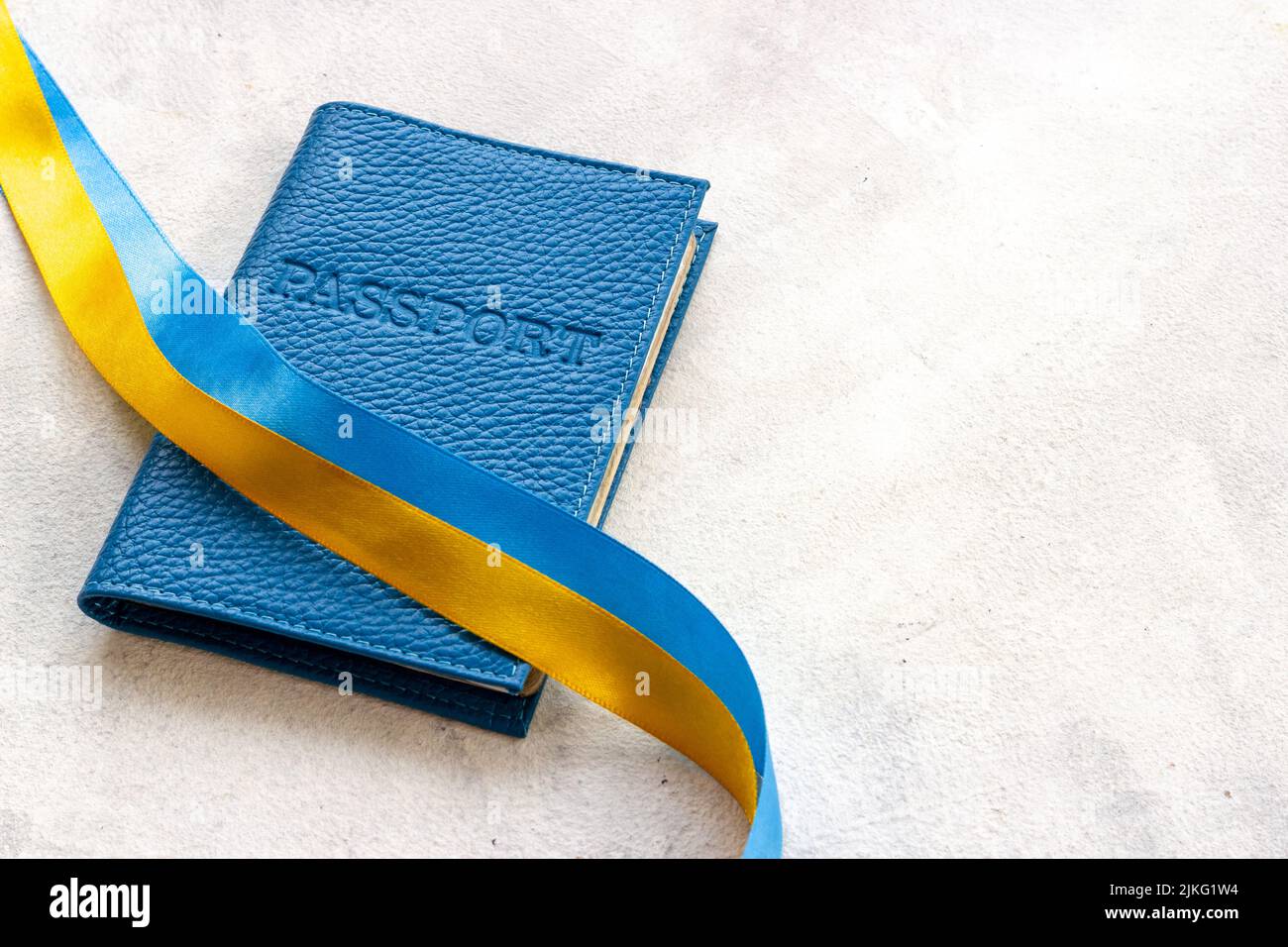 Ukrainian immigration concept - yellow and blue ribbon on passport ...