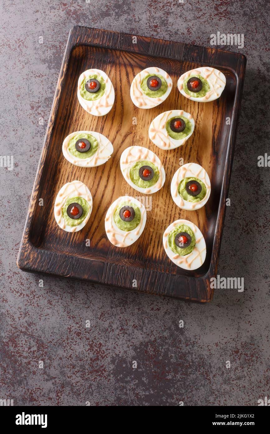 Halloween Monster eyes deviled Eggs stuffed with avocado cream wooden ...