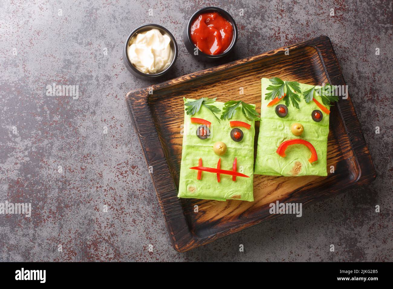 Halloween Monster Wraps burrito sandwich with funny face on a wooden ...