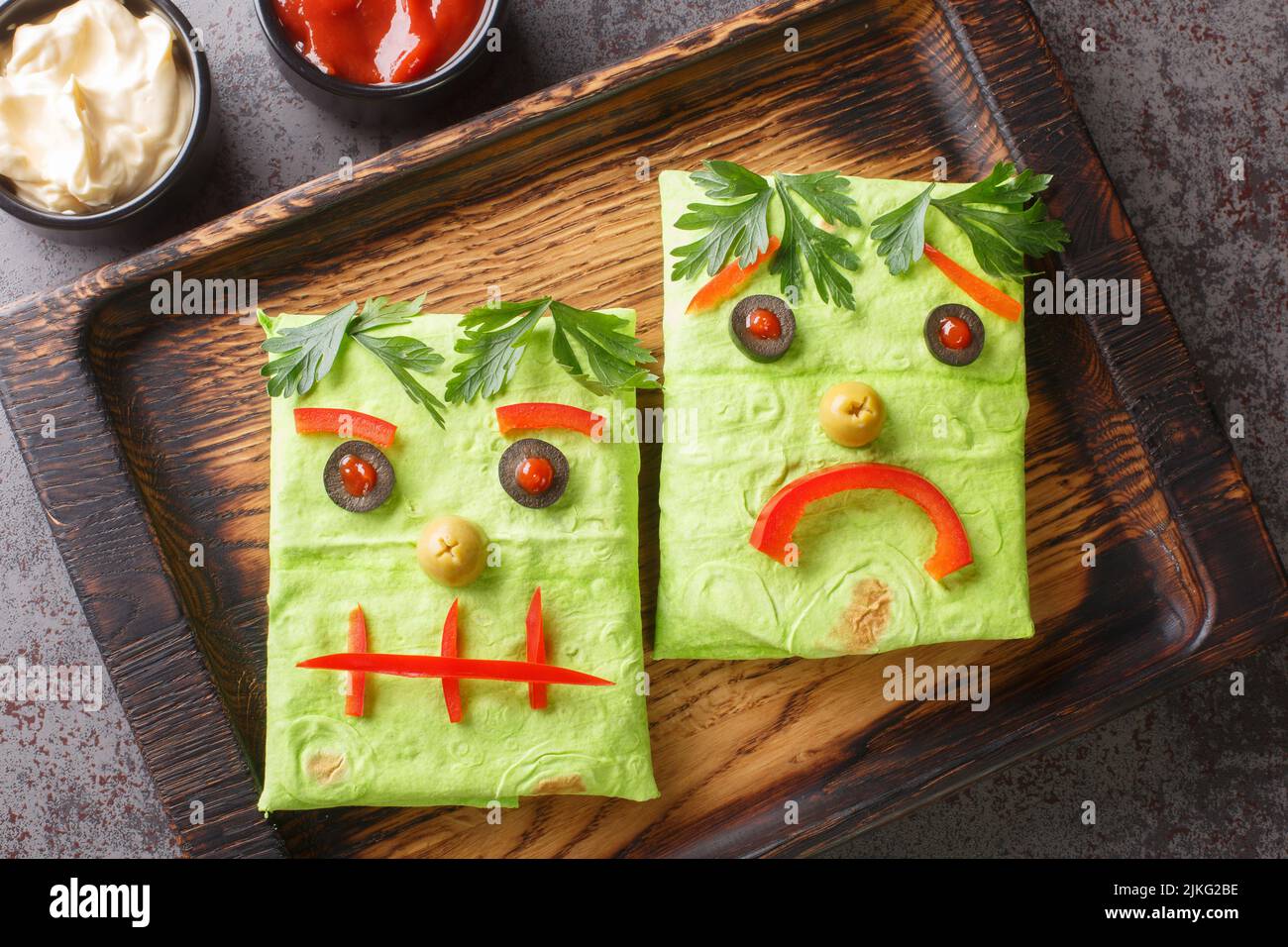 halloween fast food spinach burrito sandwich with funny face on wooden ...