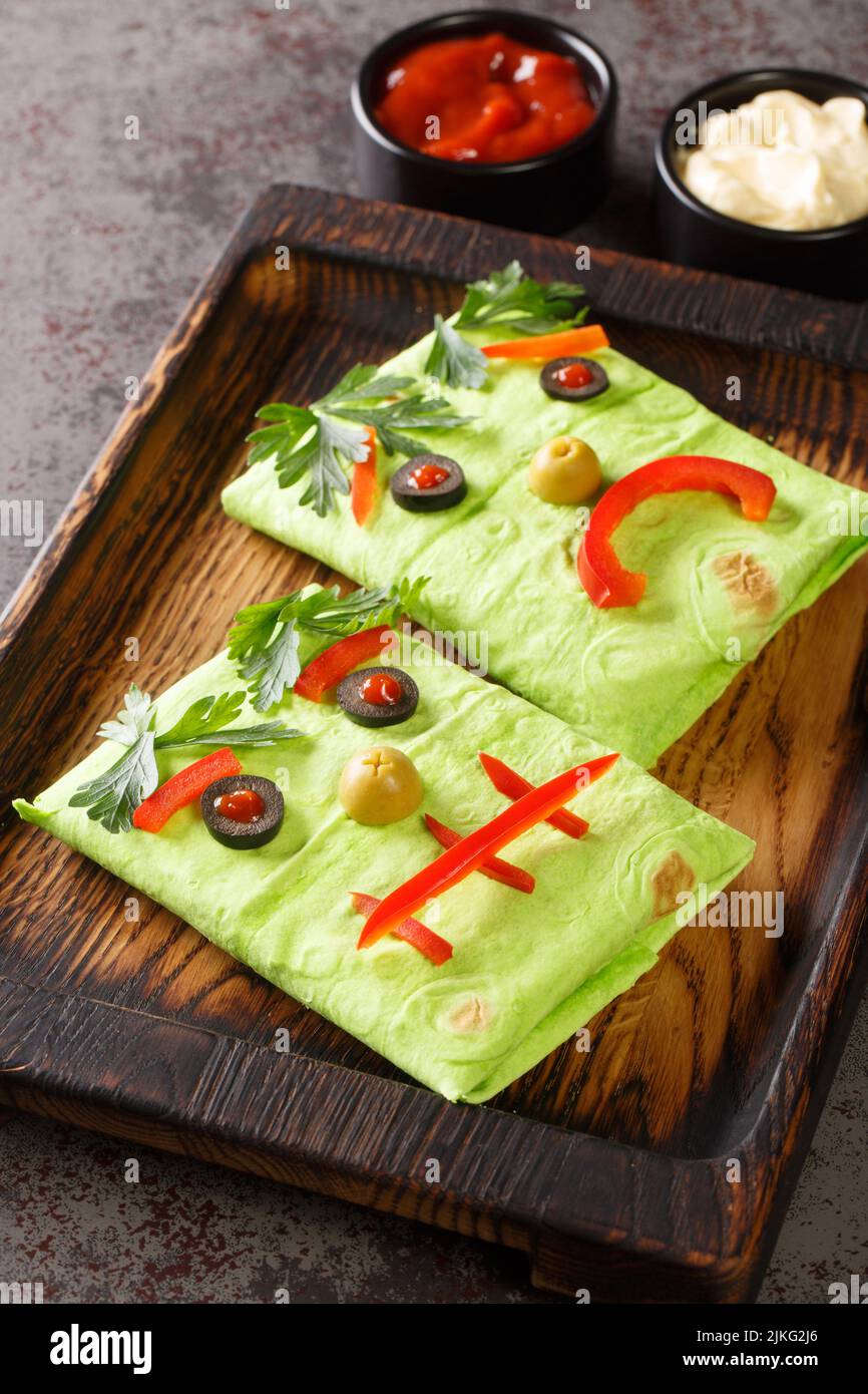 Halloween party Children's food monster burritos with sauces on a ...