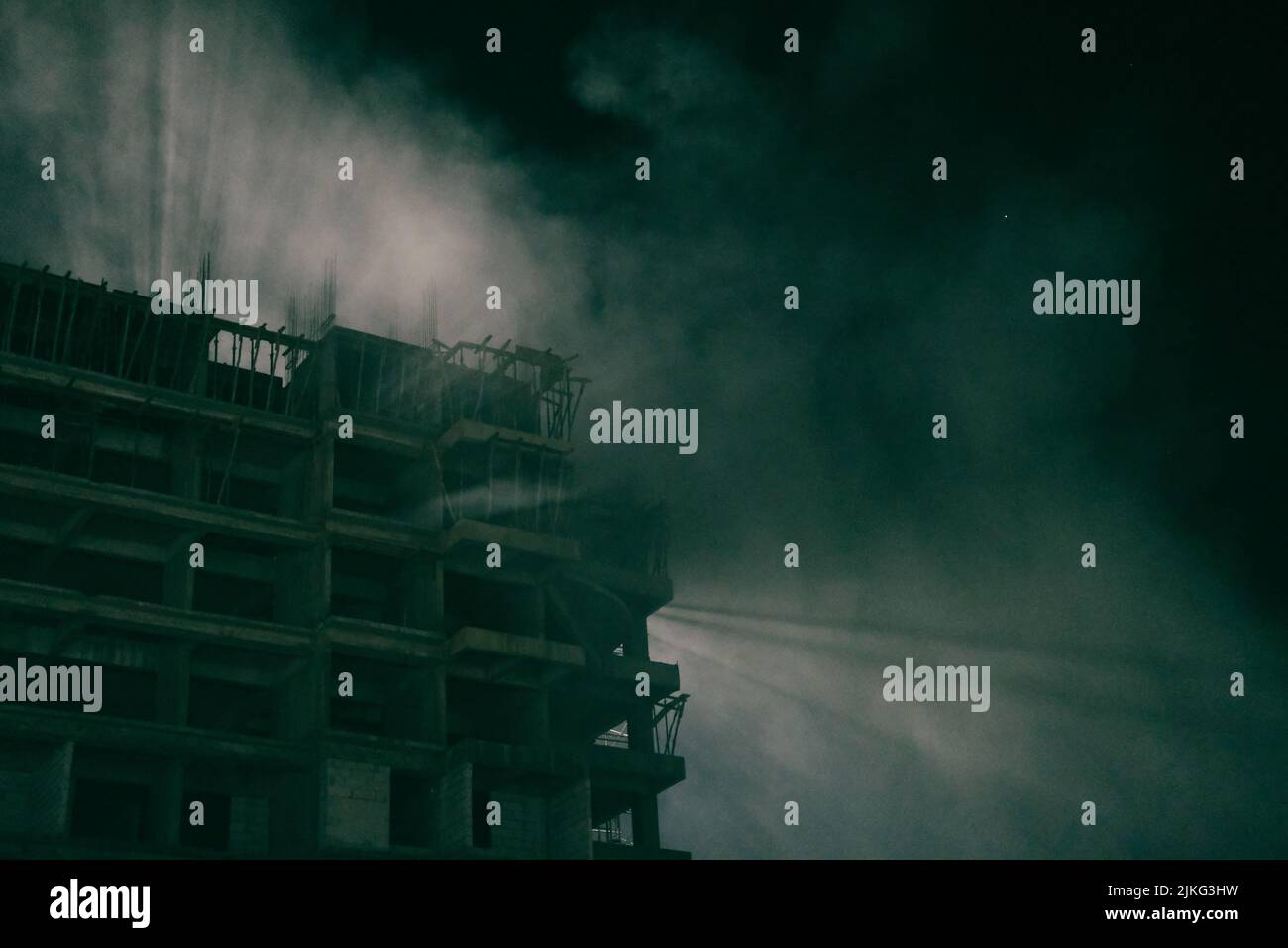 The dark, gloomy building construction work at night Stock Photo - Alamy