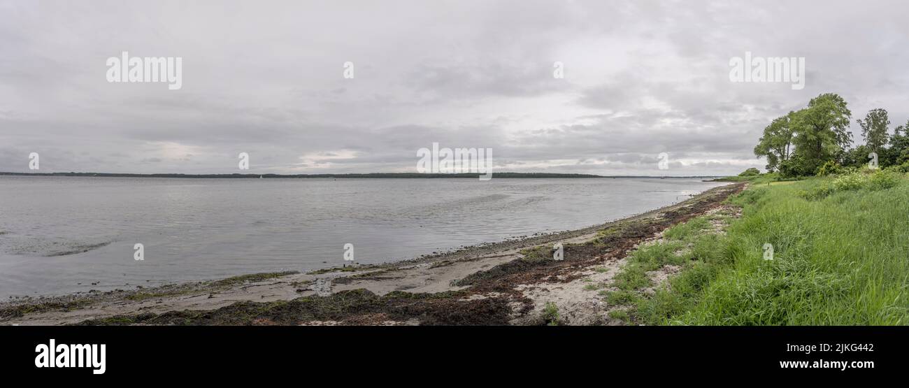 fjord landscape with sand shore and flat waters, shot under bright ...
