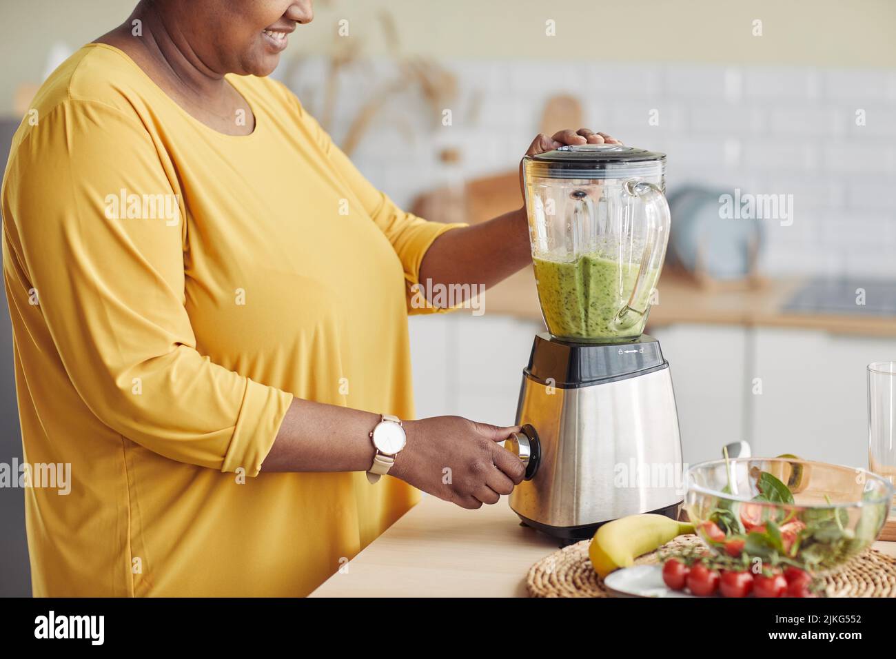 Side view closeup of black woman using blender while making healthy ...