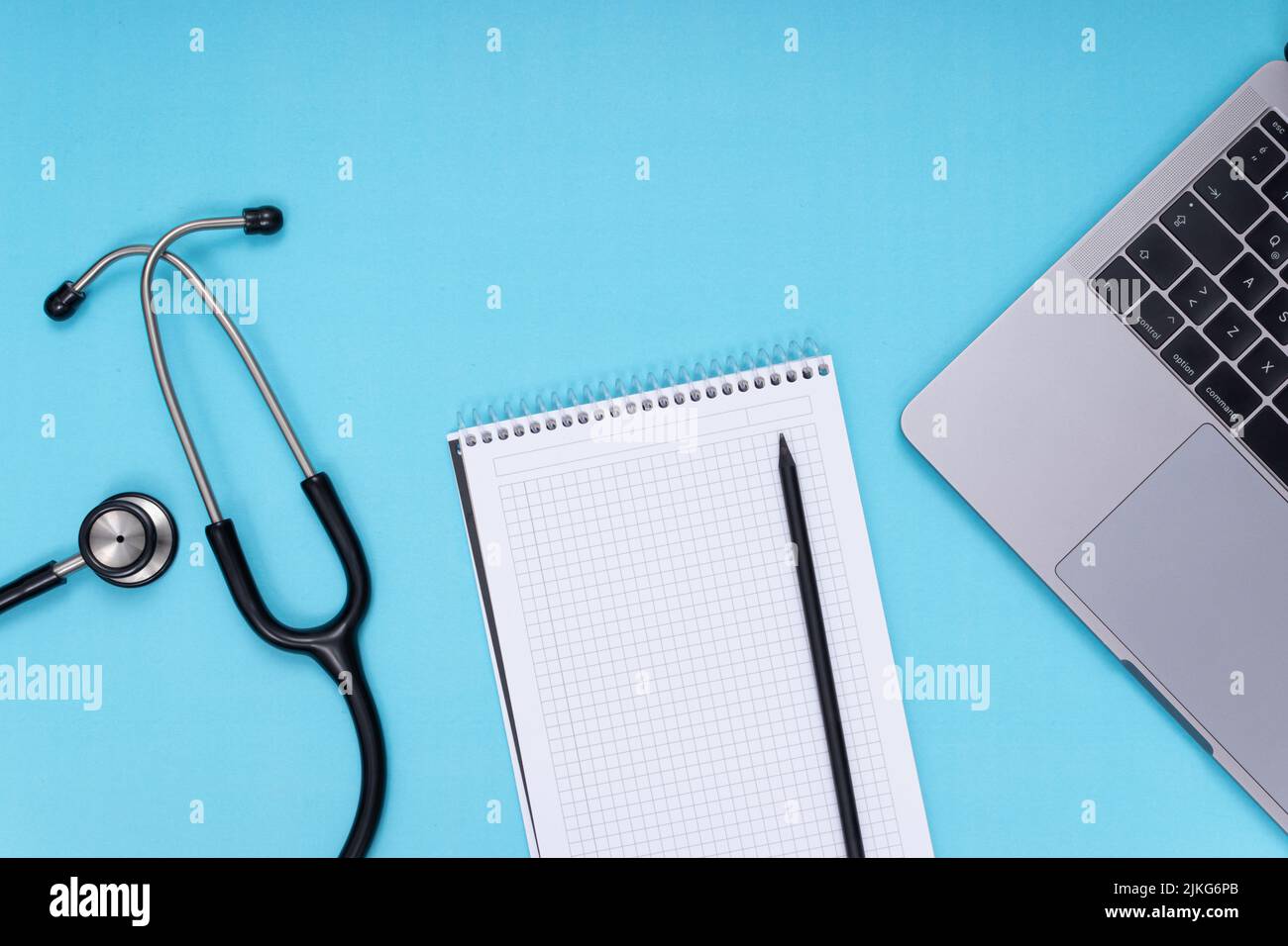black stethoscope, laptop, notepad and pen, blue isolated background ...