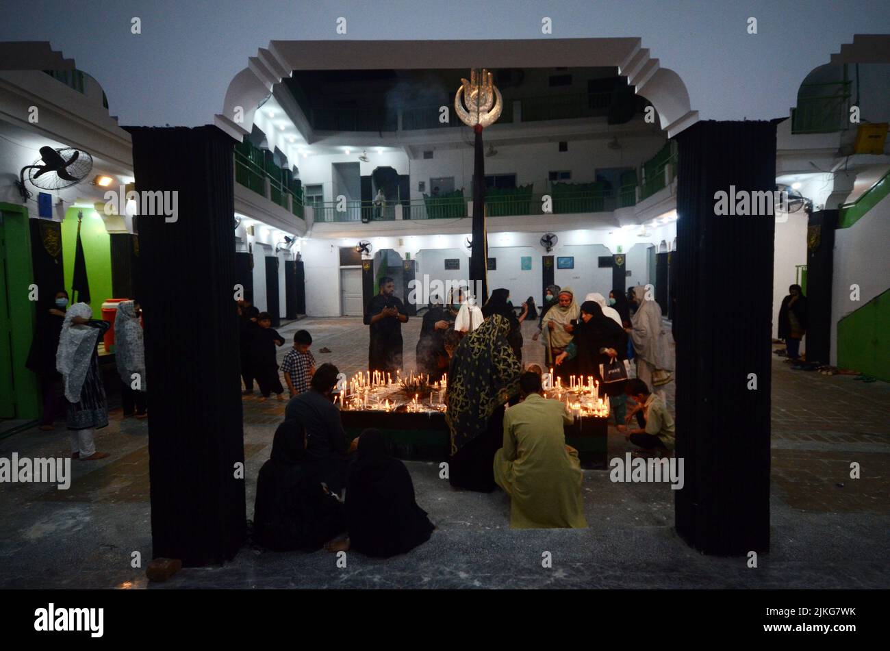 (7/30/2022) Pakistani Shiite Muslims lights candle at an Imam Bargah, a ...