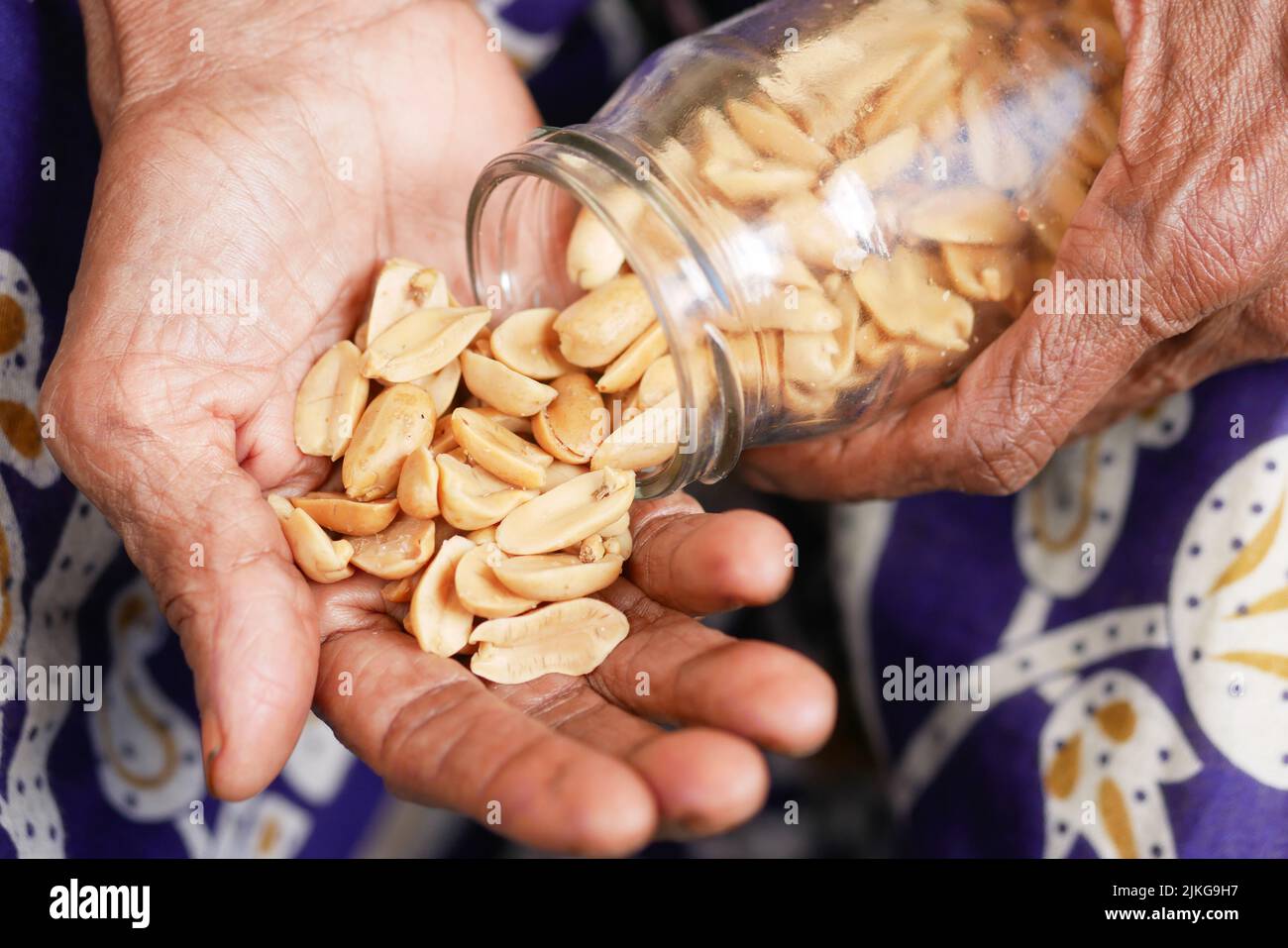 Senior women pouring peanuts hi-res stock photography and images - Alamy