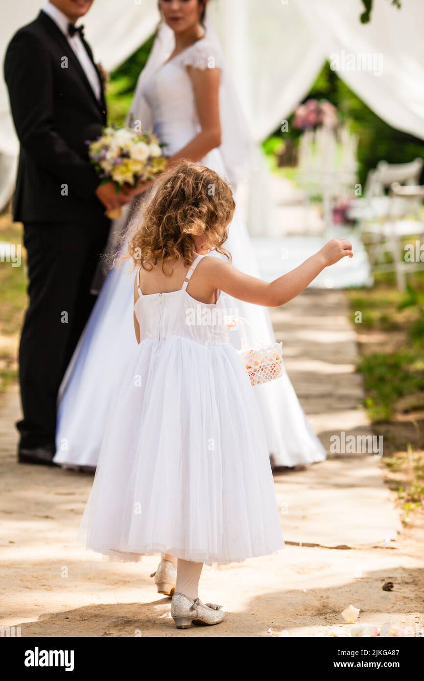 The little girl and brides at the outdoor ceremony Stock Photo - Alamy