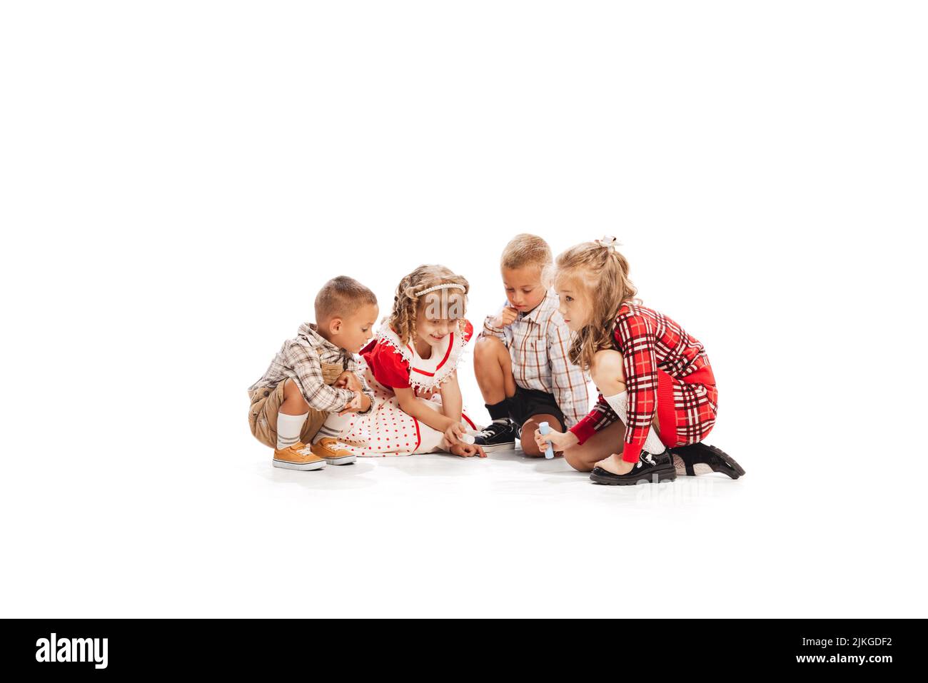 Portrait of little children, kids playing together, drawing with chalk ...