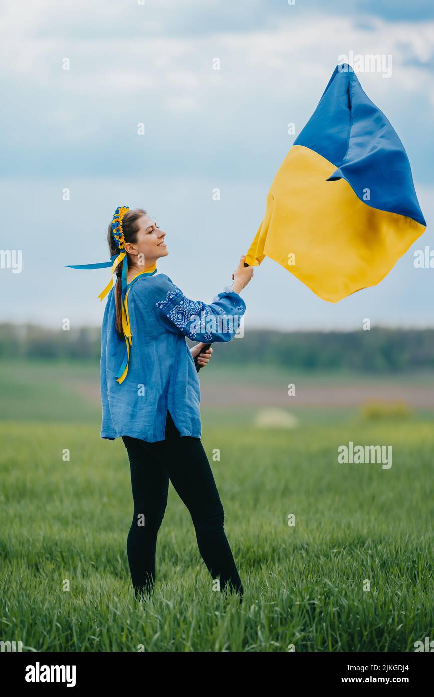 Beautiful ukrainian woman with national flag on green field background ...