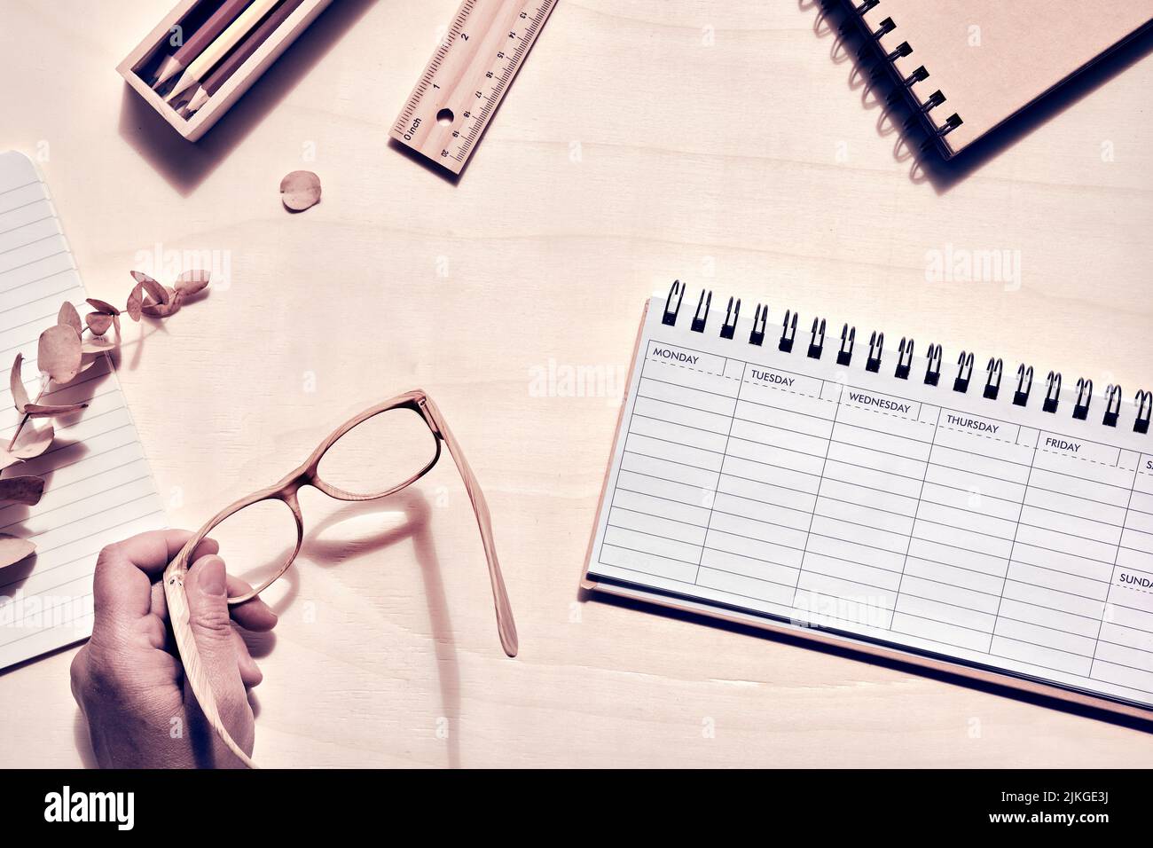 Weekly planner, writing task list. Mature old female hand with wooden ...