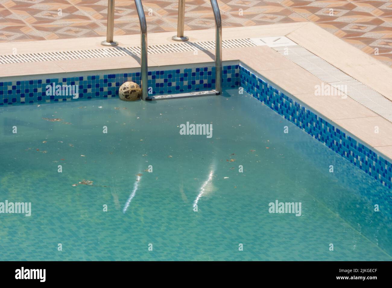An old ball floats in a pool of dirty water Stock Photo - Alamy