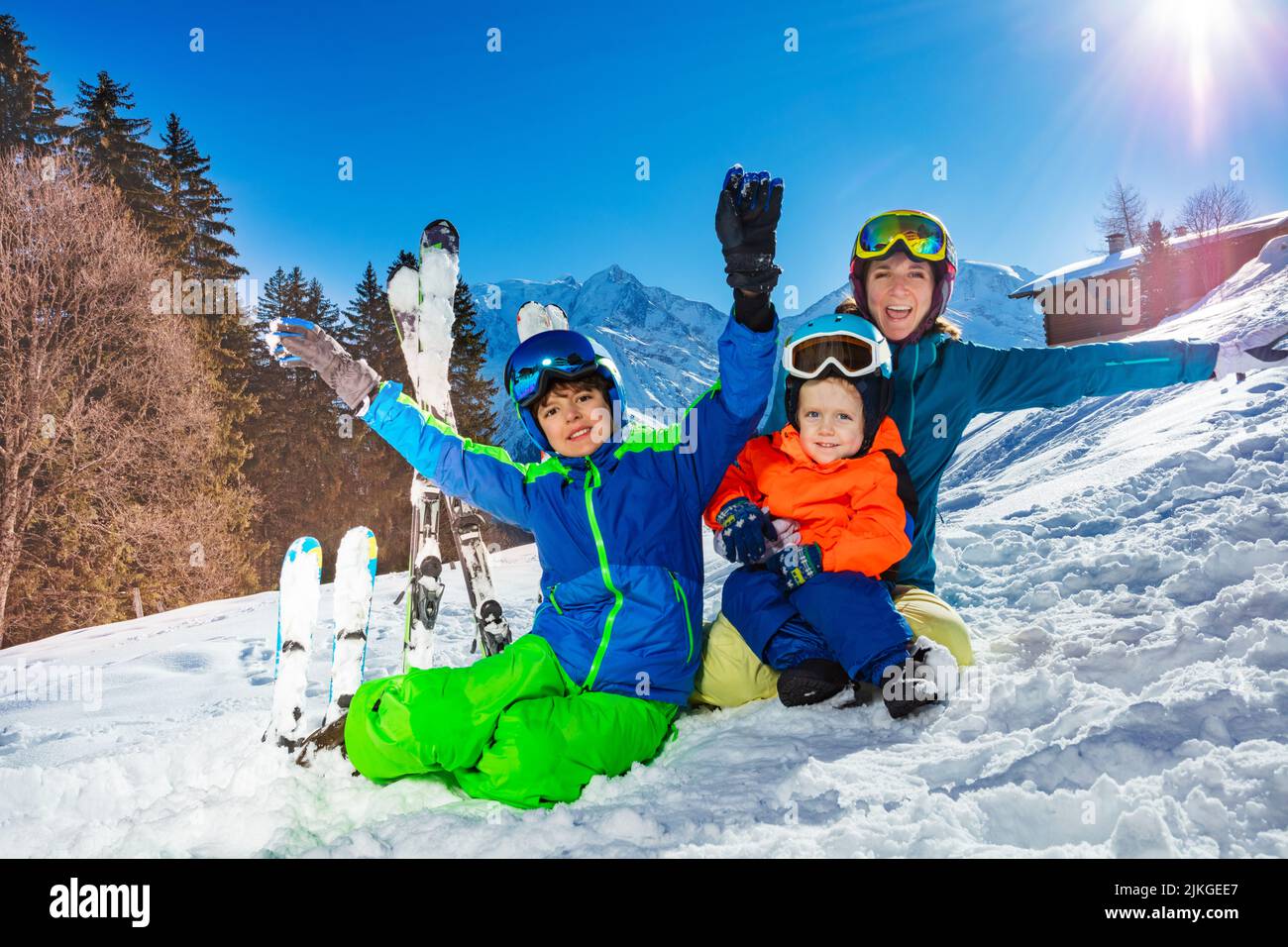 Kids and mother on ski vacation sit in the snow over Mont Blanc Stock ...