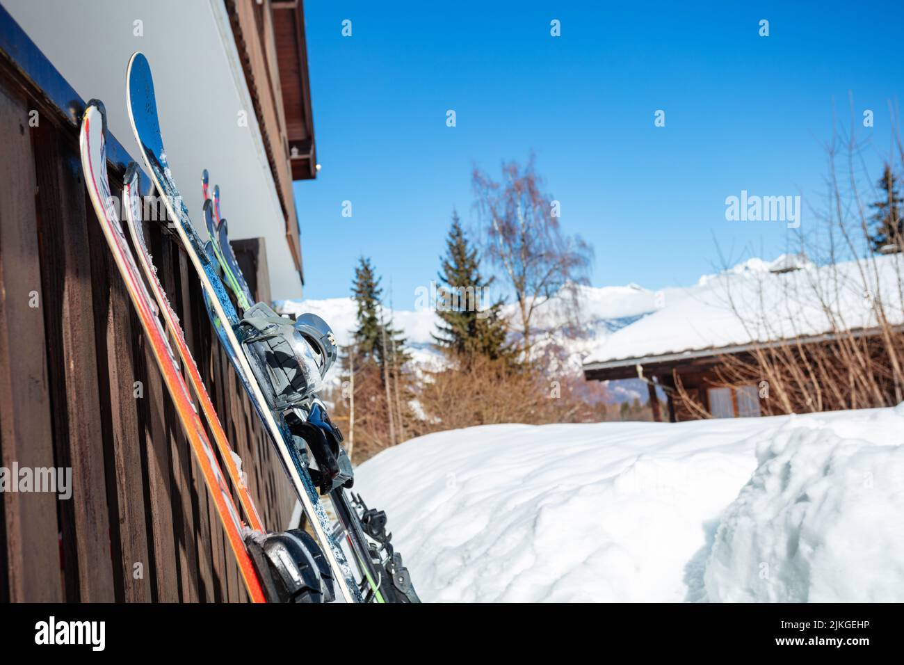 Snowboards and skis stand on alpine resort near building Stock Photo ...