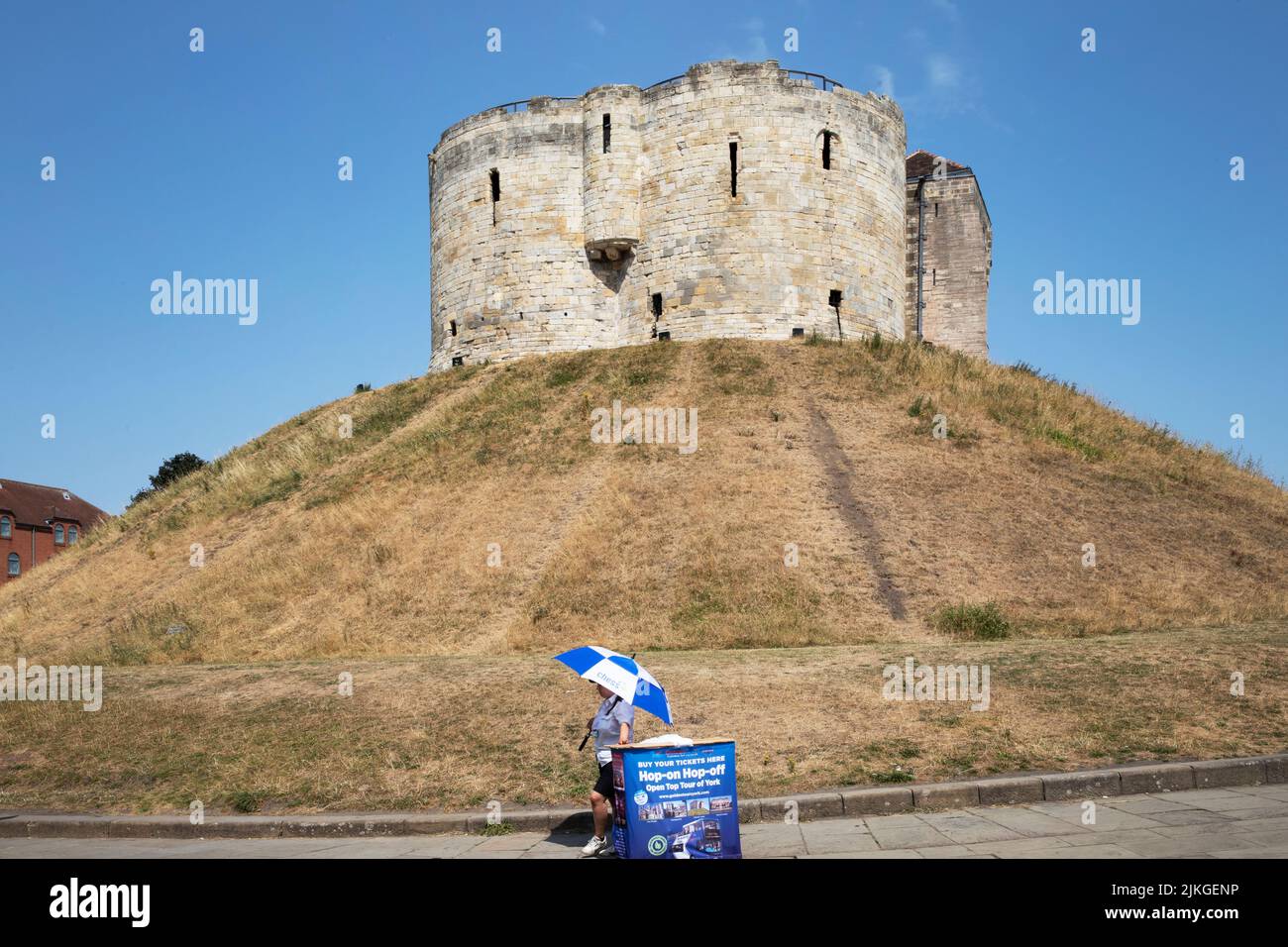 A tour operater taking shelter from the sun near Castlegate, York ...
