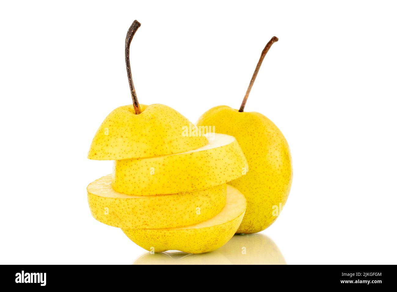 One juicy yellow pear cut into quarters and one whole pear, close-up ...