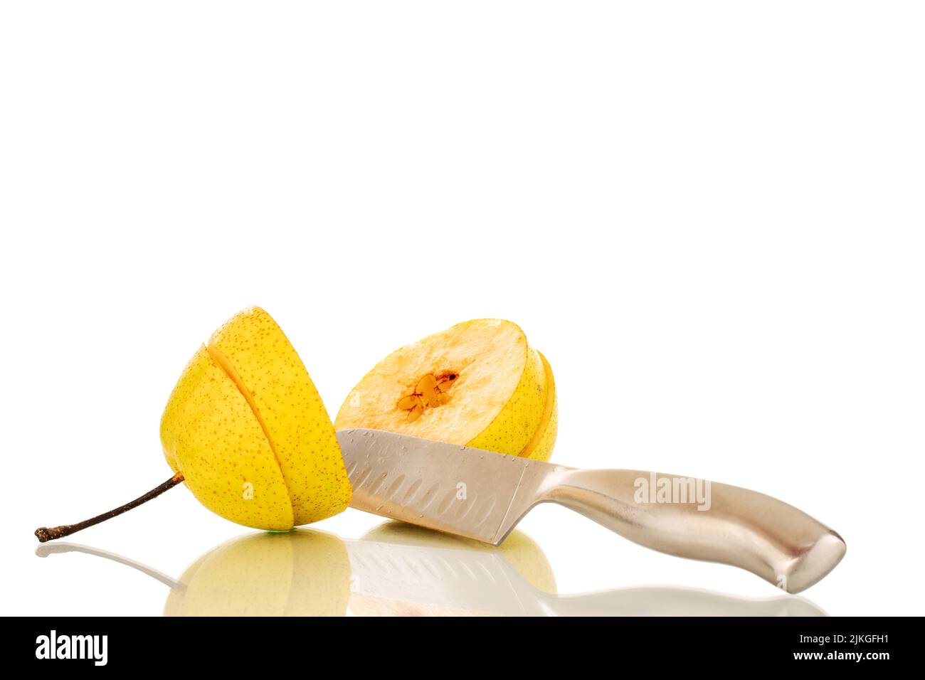 One juicy yellow pear cut into quarters with a metal knife, close-up ...