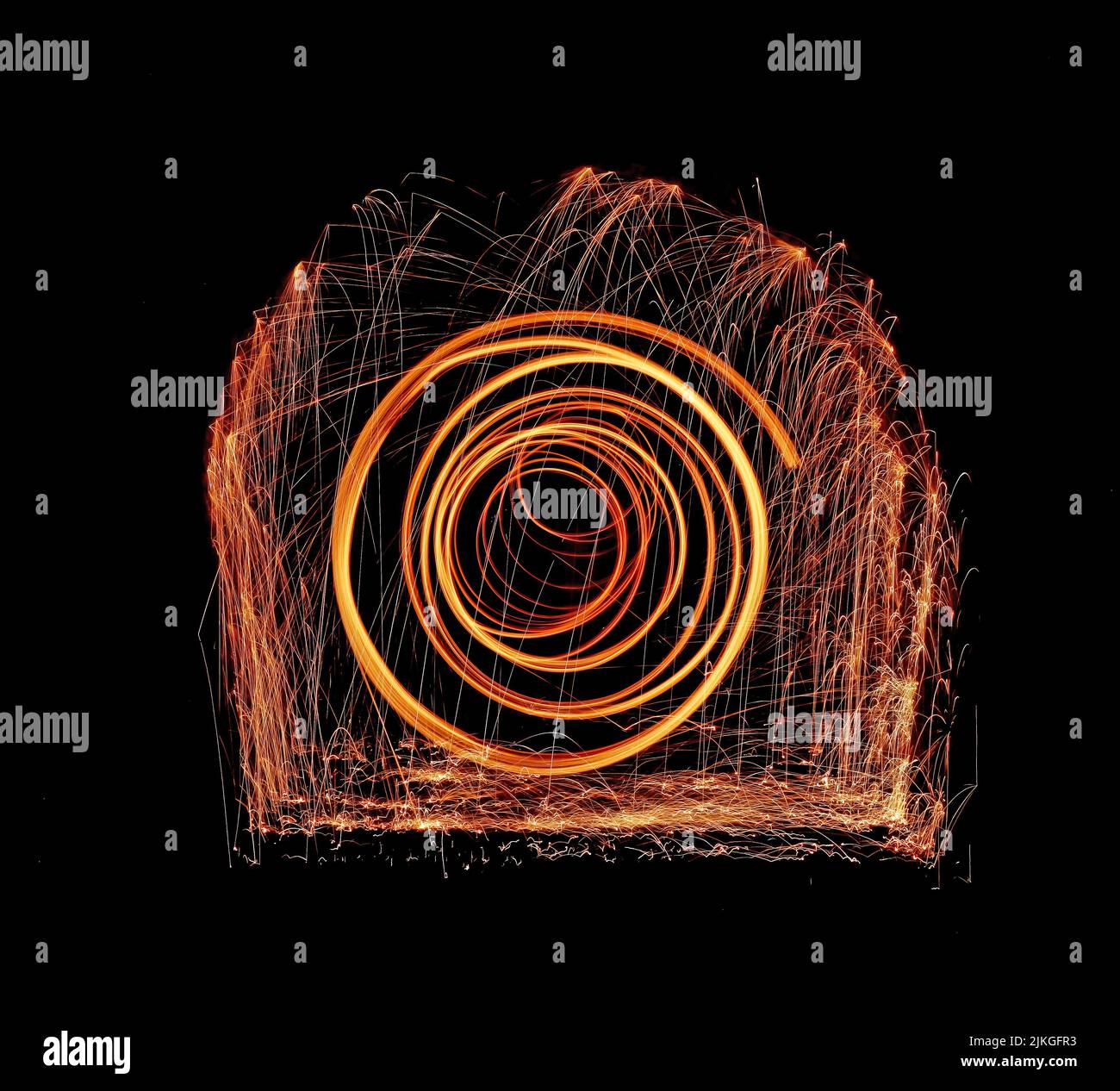 Steel wool spinning in a tunnel, throwing off yellow and orange sparks ...