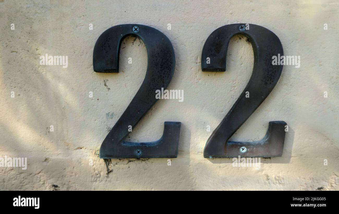 metal number 22 outdoors on cream wall Stock Photo - Alamy