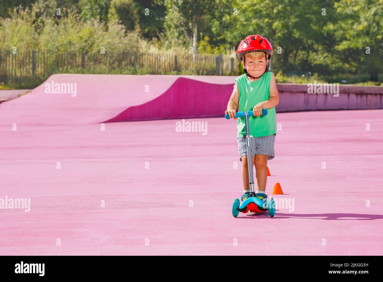 Cute small boy with smiling on kick scooter ride at skate park Stock ...