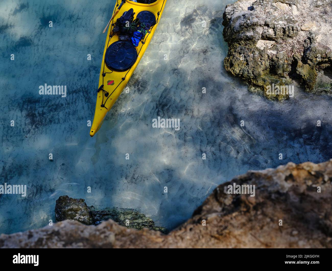 Yellow sea kayak ready on the sea by the rock Stock Photo - Alamy