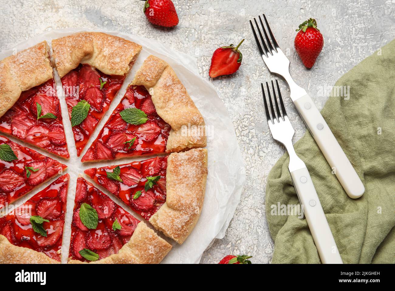 Fresh strawberry galette, fresh berries and forks on light background ...