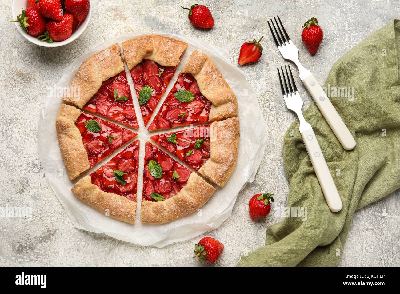 Fresh strawberry galette, fresh berries and forks on light background ...