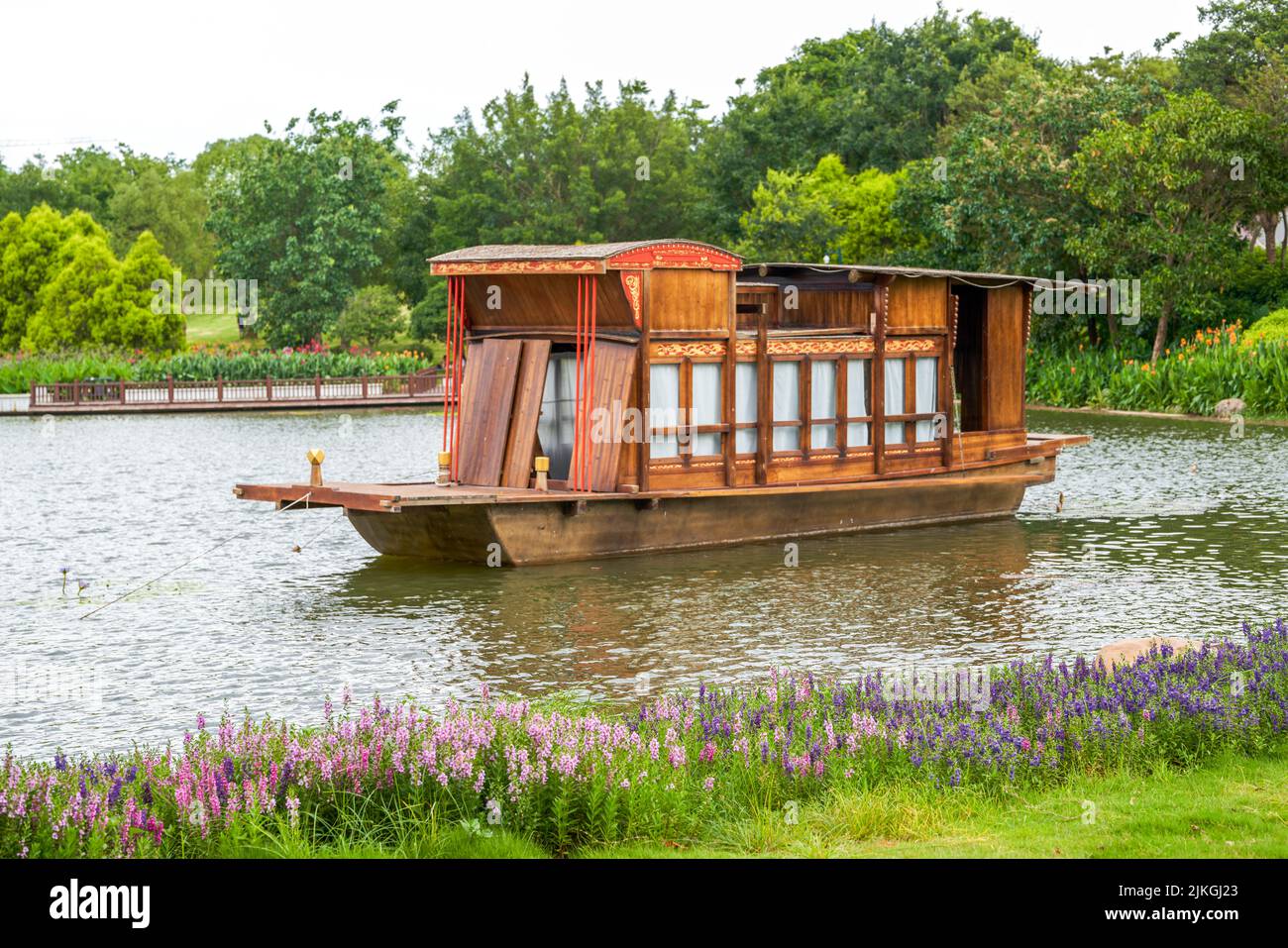 This traditional Chinese wooden boat is moored on the lake in the park ...