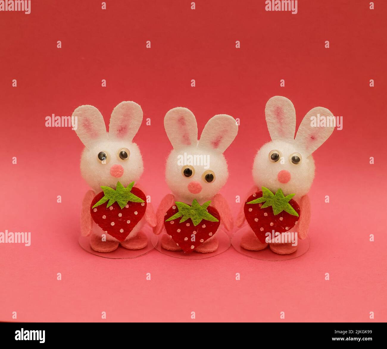Three novelty Easter bunny figurines holding strawberries made from ...