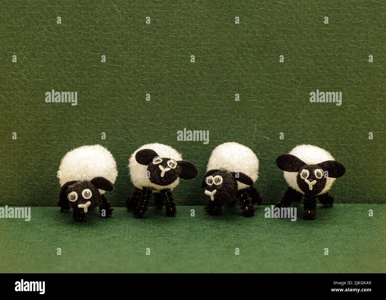 Four novelty, Easter pipe-cleaner, pompom sheep on a green, grass-like ...