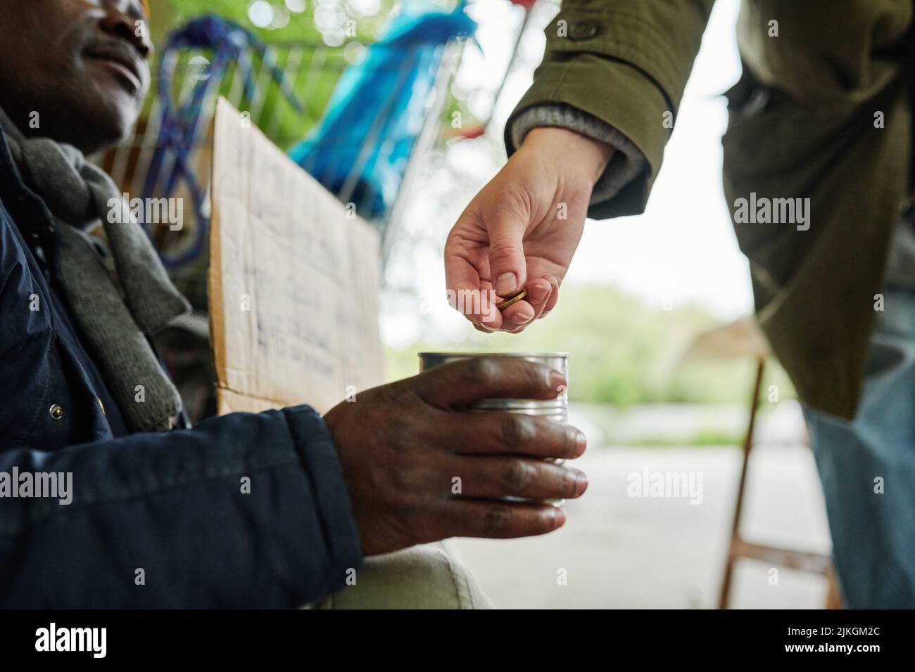 Close-up of man giving money to homeless man while he begging outdoors ...