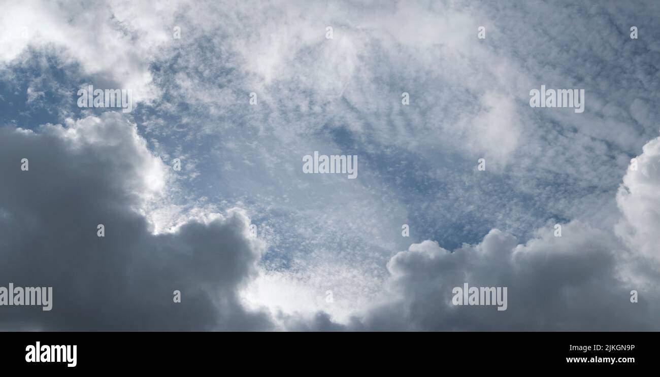 heavy clouds rolling in over a blue sky Stock Photo - Alamy