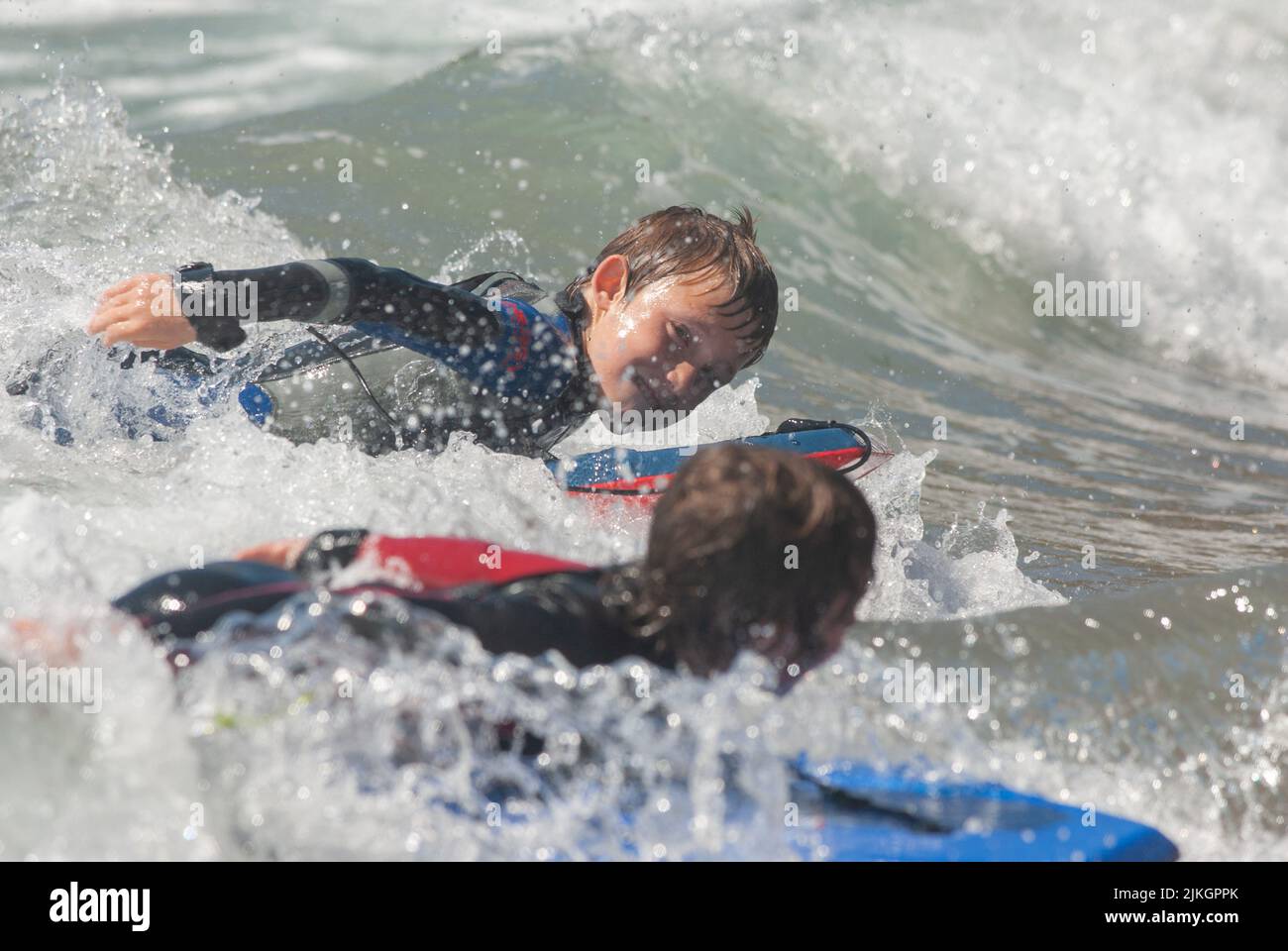 Two boys boogie boarding at West Dale beach, Pembrokeshire, Wales, UK ...