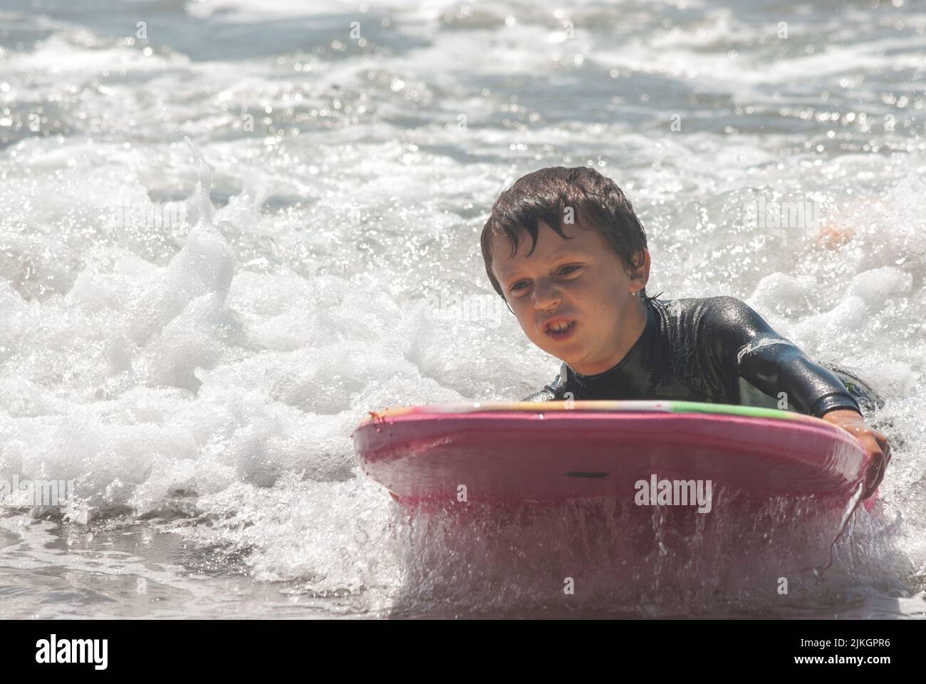 Boy boogie boarding at West Dale beach, Pembrokeshire, Wales, UK Stock ...