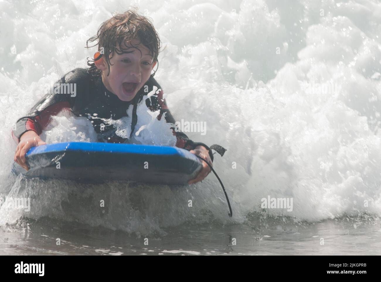 Boy boogie boarding at West Dale beach, Pembrokeshire, Wales, UK Stock ...