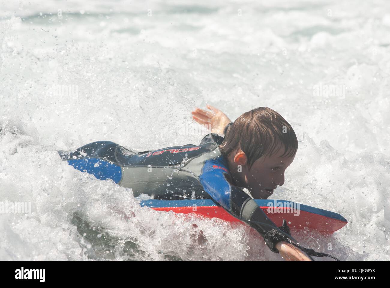 Boy boogie boarding at West Dale beach, Pembrokeshire, Wales, UK Stock ...