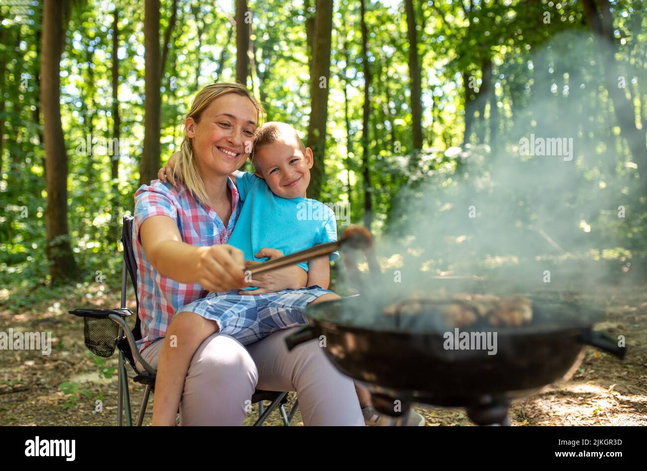 A happy mother and son making barbecue in the nature Stock Photo - Alamy