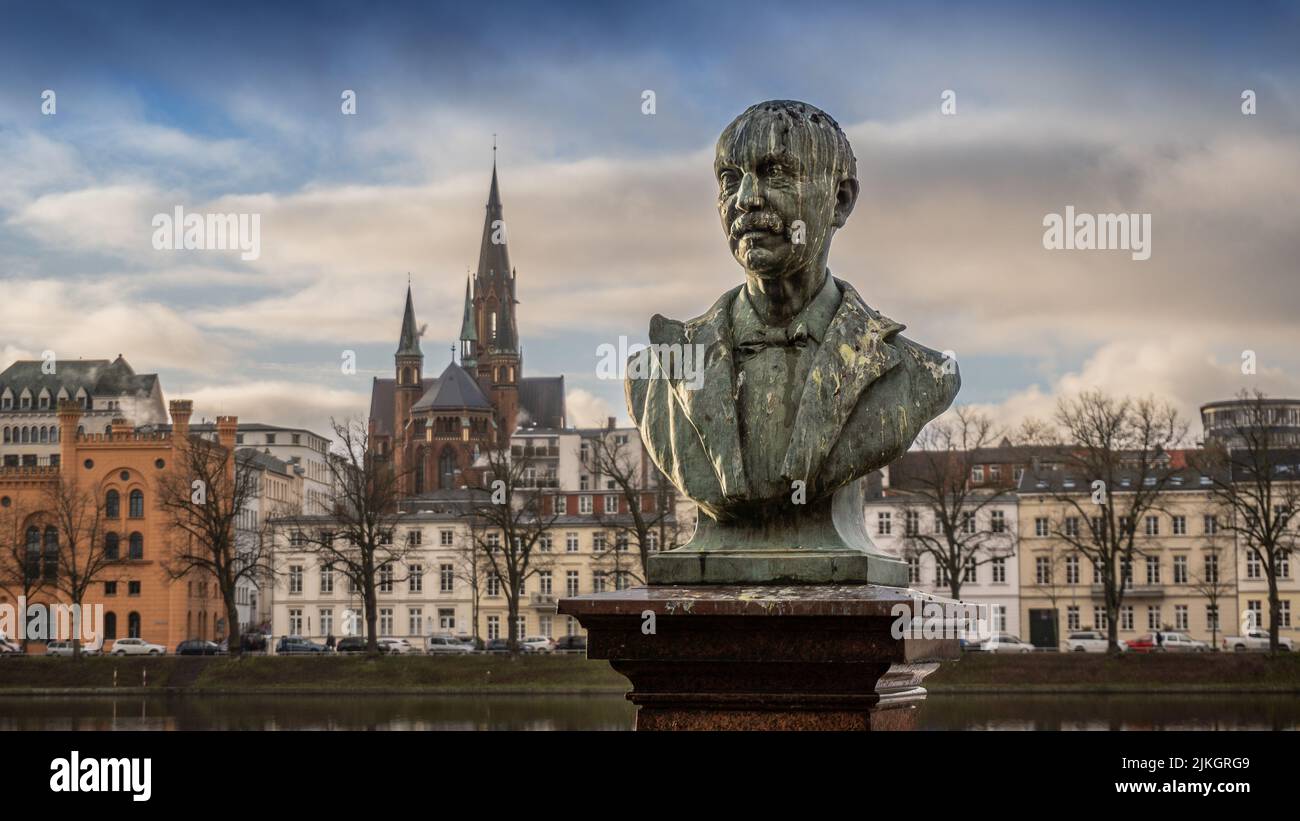 The bust of Heinrich Schliemann against blue cloudy sky background in ...